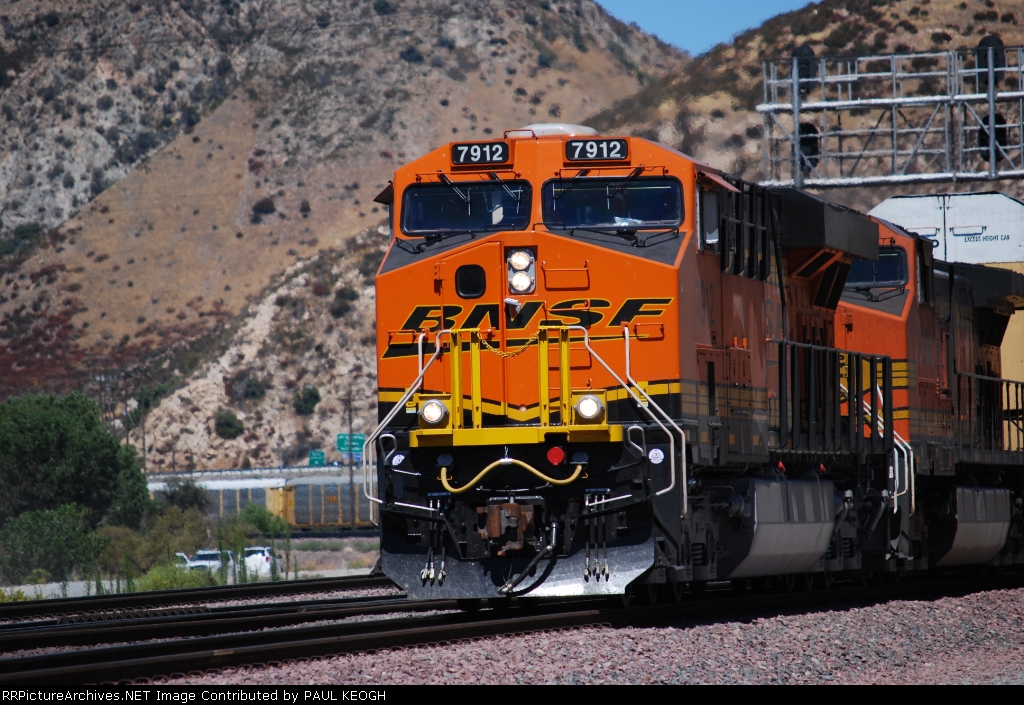 BNSF 7912 rolls toward the bottom of Cajon Pass pulling a load of cars.